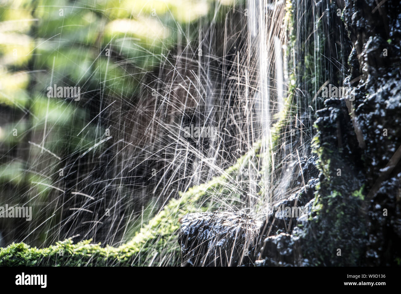 Water drops jumping from rock. Small waterfall, close up view. Water ...