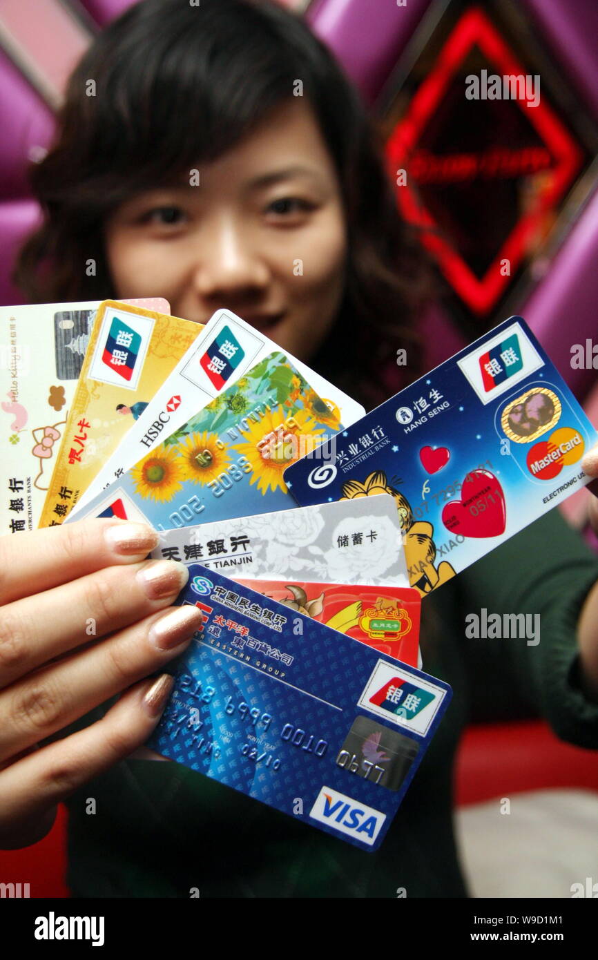 --FILE--A Chinese woman shows credit cards with the logos of China ...