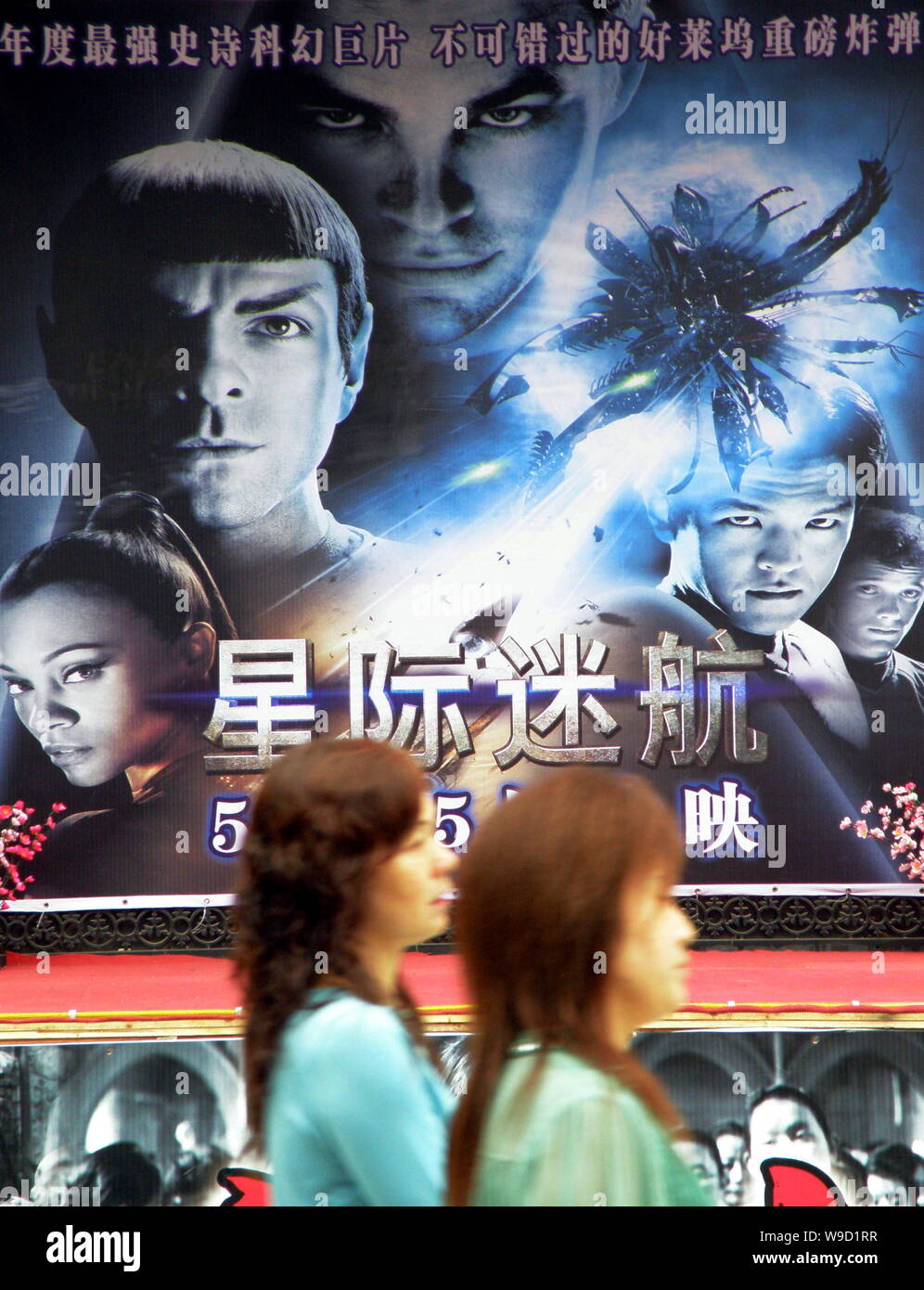 --FILE--Young Chinese women walk past a poster of the movie Star Trek ...