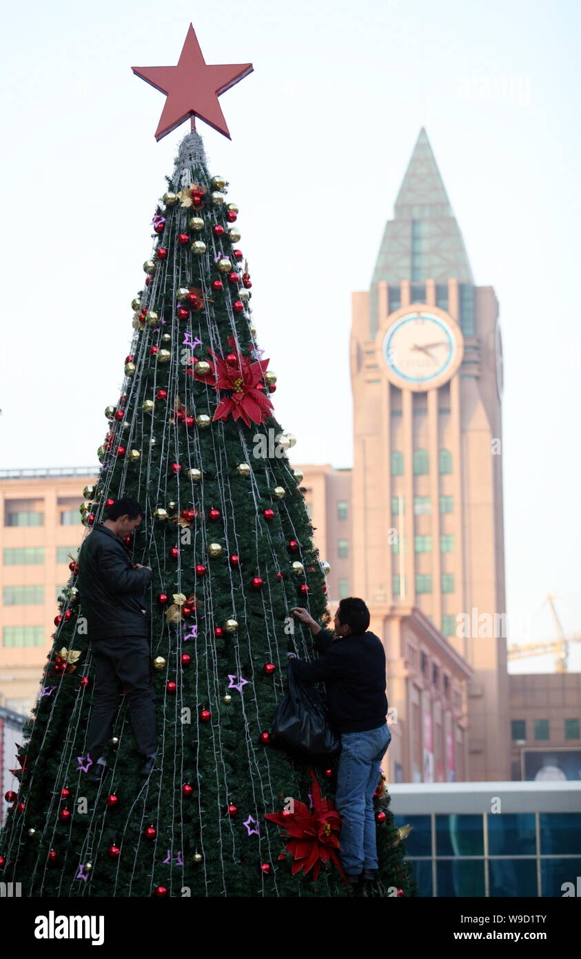Chinese workers decorate a Christmas tree on the Wangfujing shopping ...