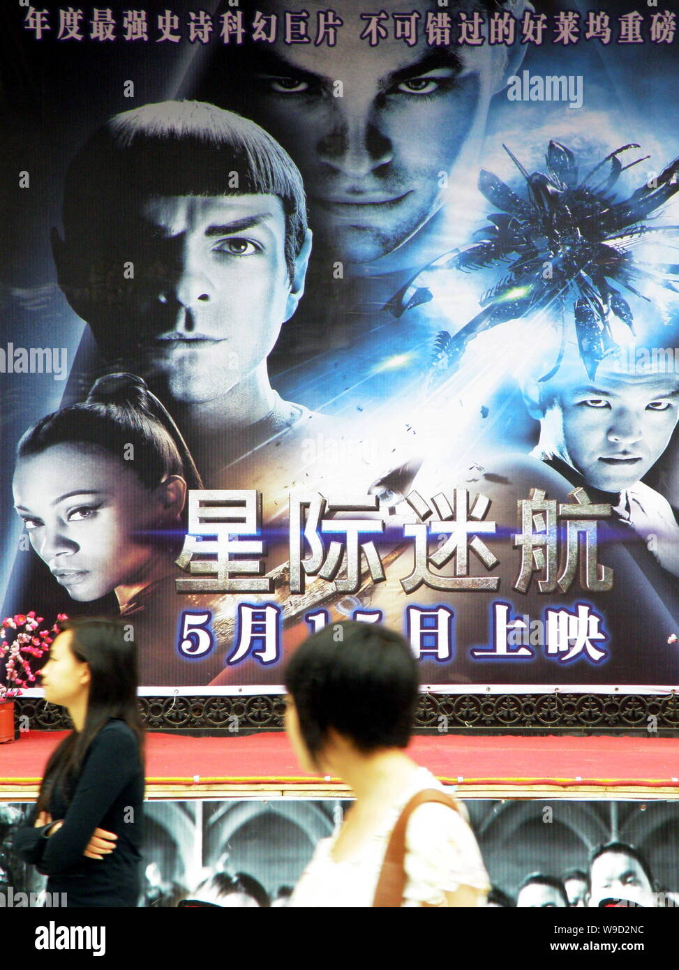 --FILE--Young Chinese women walk past a poster of the movie Star Trek ...