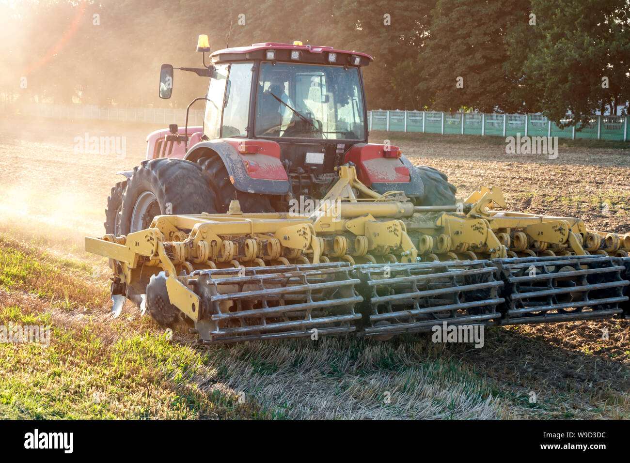 tractor cultivator plows the land, prepares for crops. dust on field ...