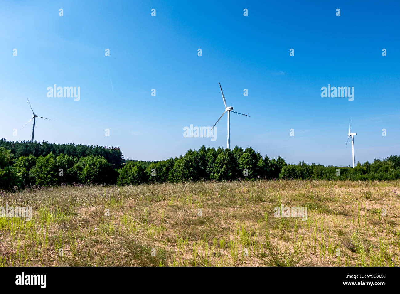 rotating blades of a windmill propeller on blue sky background. Wind ...