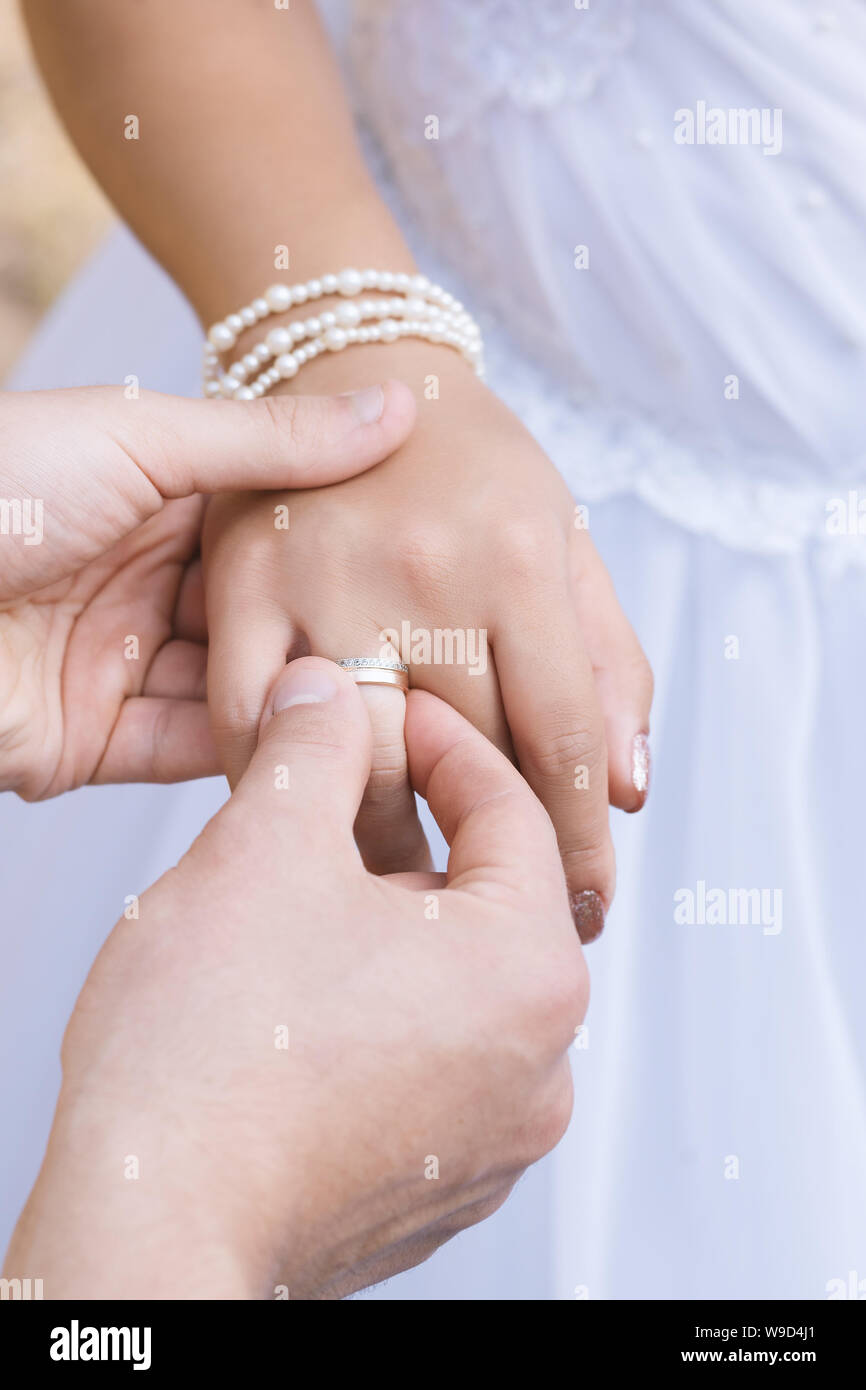 Couple's hands holding wedding rings, close up Stock Photo - Alamy