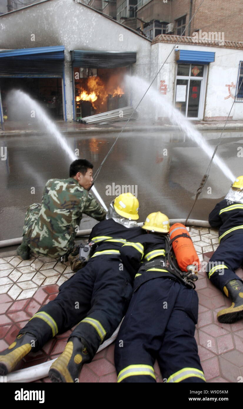Chinese firemen try to extinguish a fire in an LPG tank storage station ...