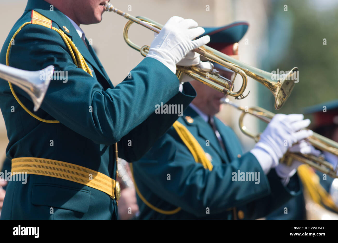 A wind instrument parade - men in green costumes playing trumpet Stock ...