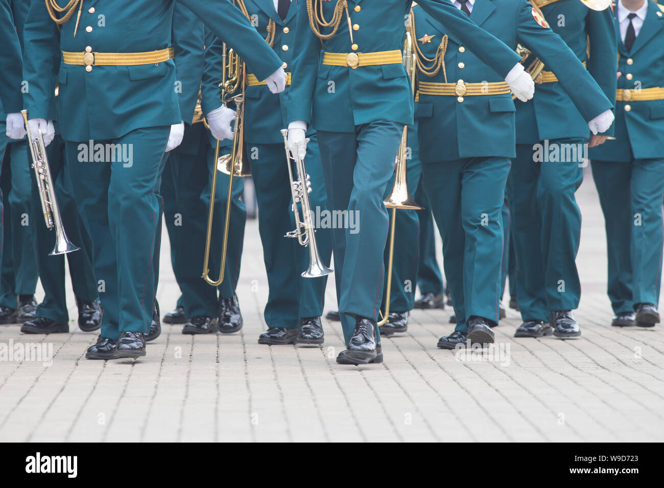 A wind instrument parade - people in green costumes walking on the ...