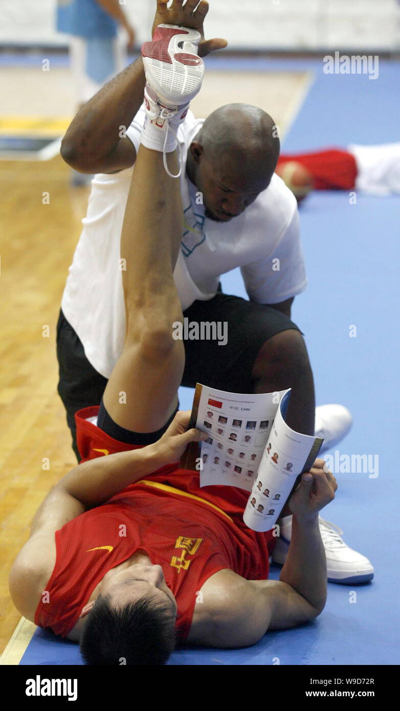 A team member of the Chinese national men basketball team helps Yi ...