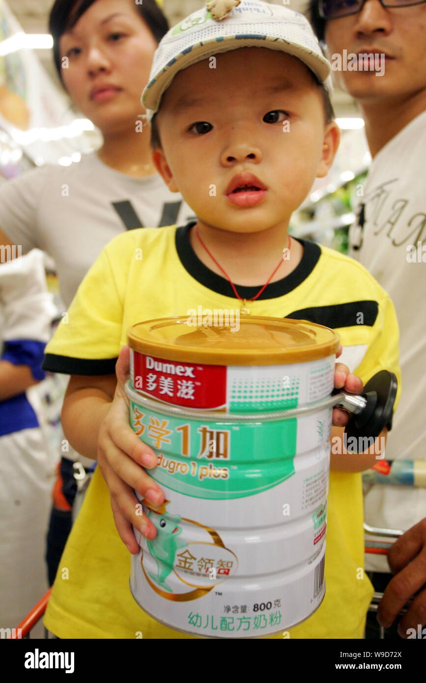 --FILE--A Chinese child shows a tin of Dumex milk powder at a ...
