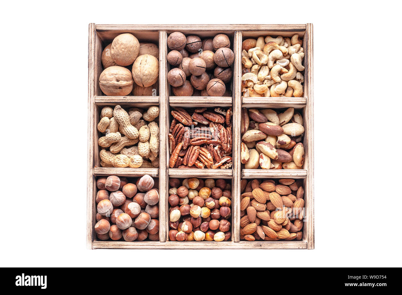 Wooden box with different kinds of nuts on a white background. Top view ...