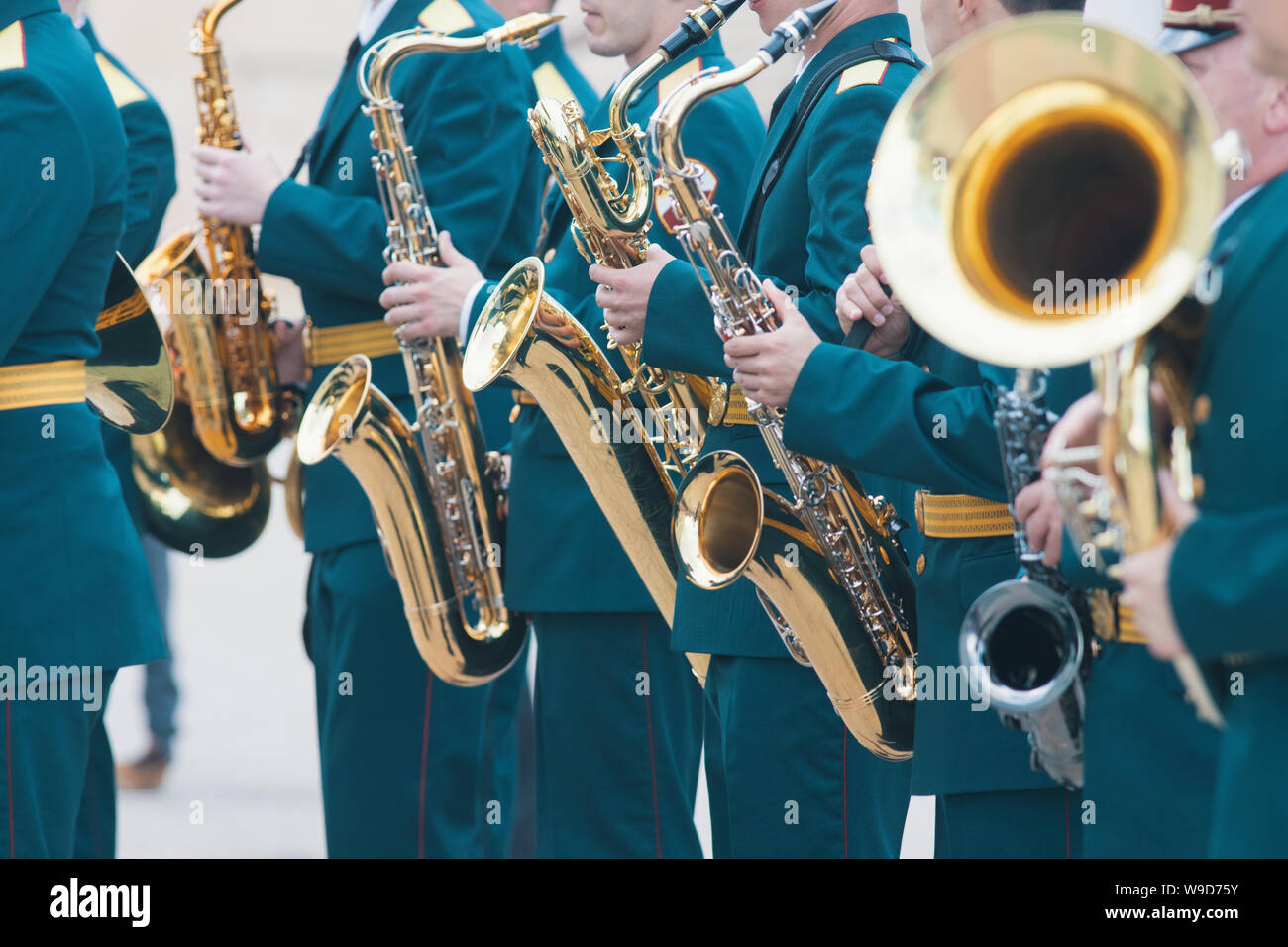 A wind instrument parade - people in green costumes holding saxophone ...