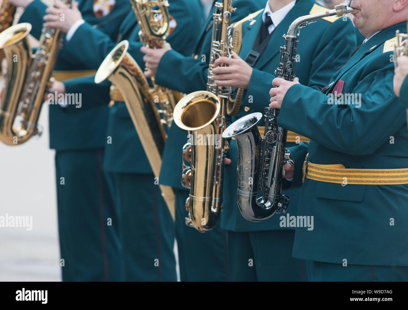 A wind instrument parade - people in green costumes playing saxophone ...