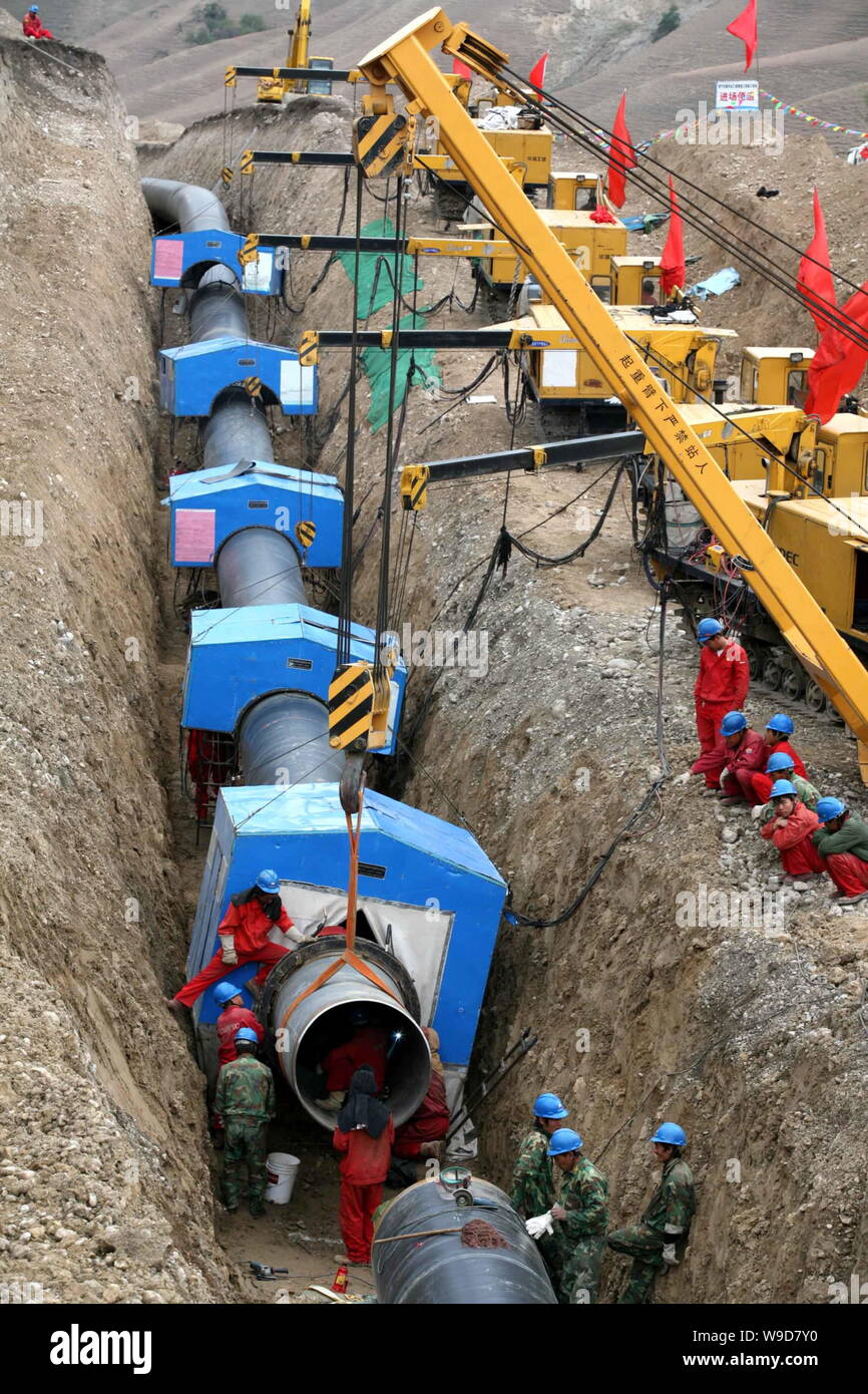 --FILE--Chinese workers lay a pipeline at a construction site of the ...