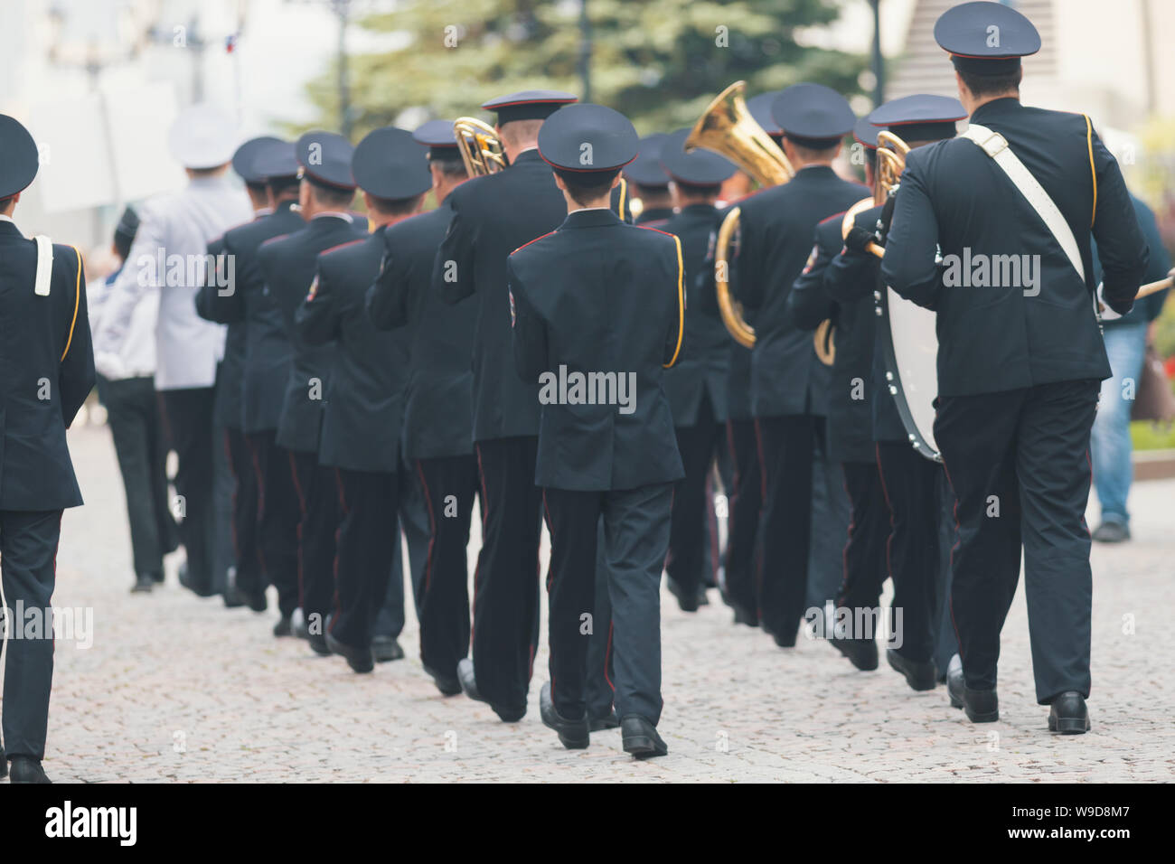 A wind instrument parade - people in costumes walking on the street ...