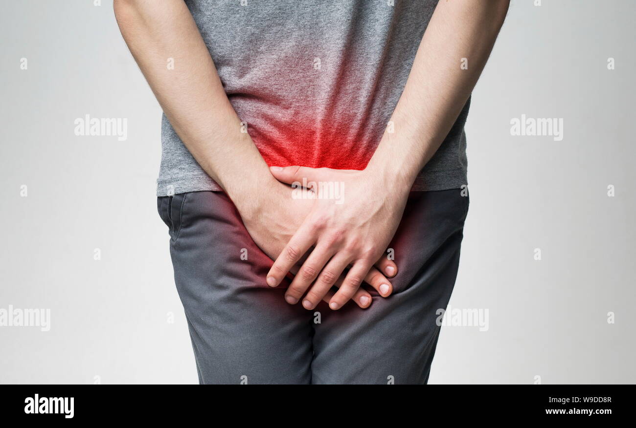 Man holding his urethra in pain. Men problems Stock Photo - Alamy