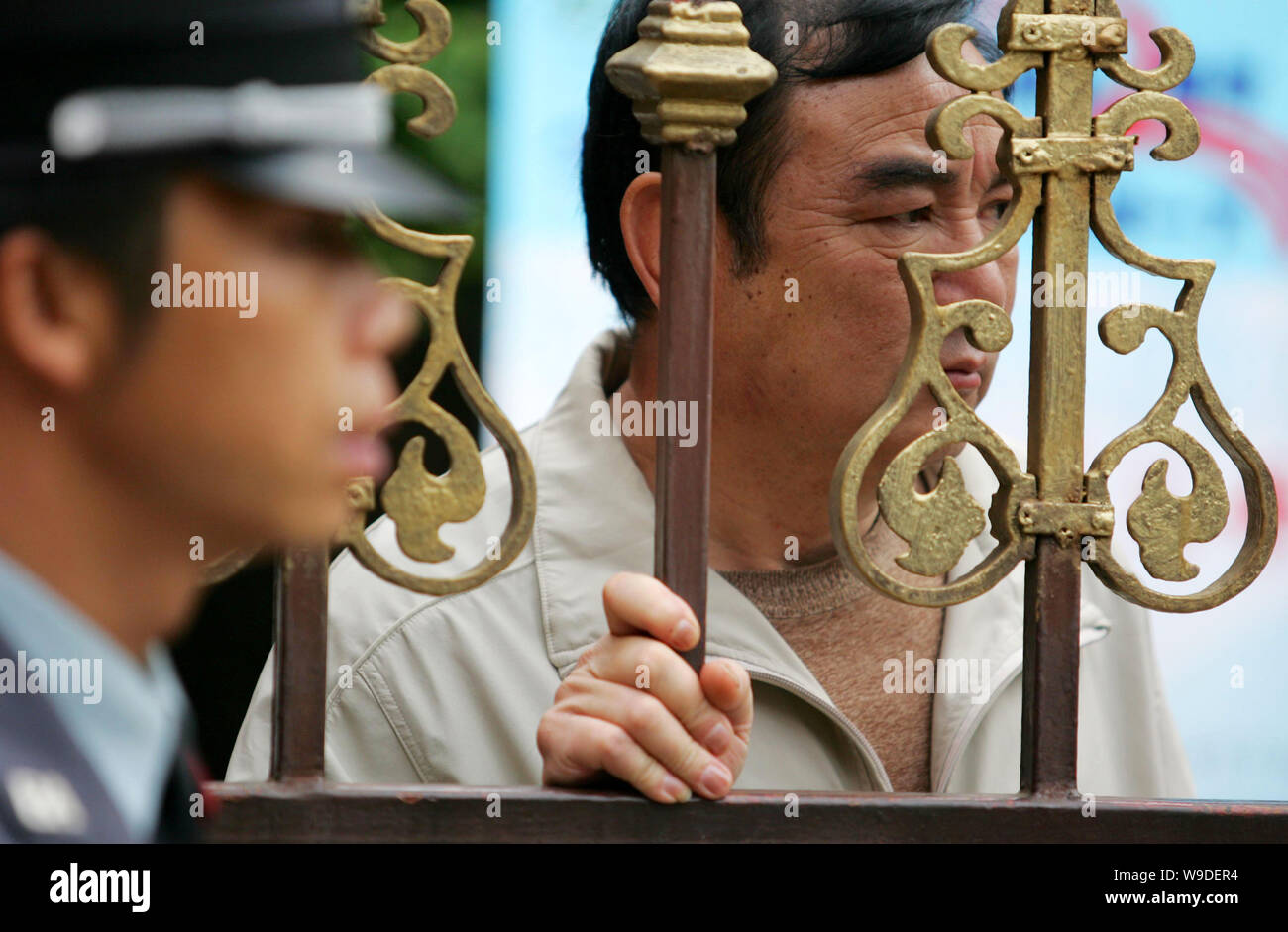 A Chinese father waits close to a security guard outside a middle ...