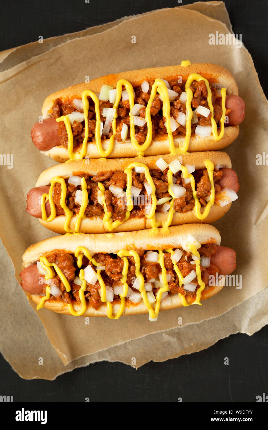 Homemade Detroit style chili dog on a black background, directly above ...
