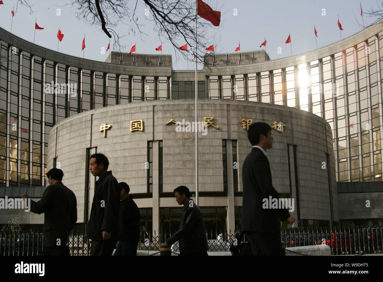 --FILE-- Chinese passers-by walk past the headquarters and head office ...