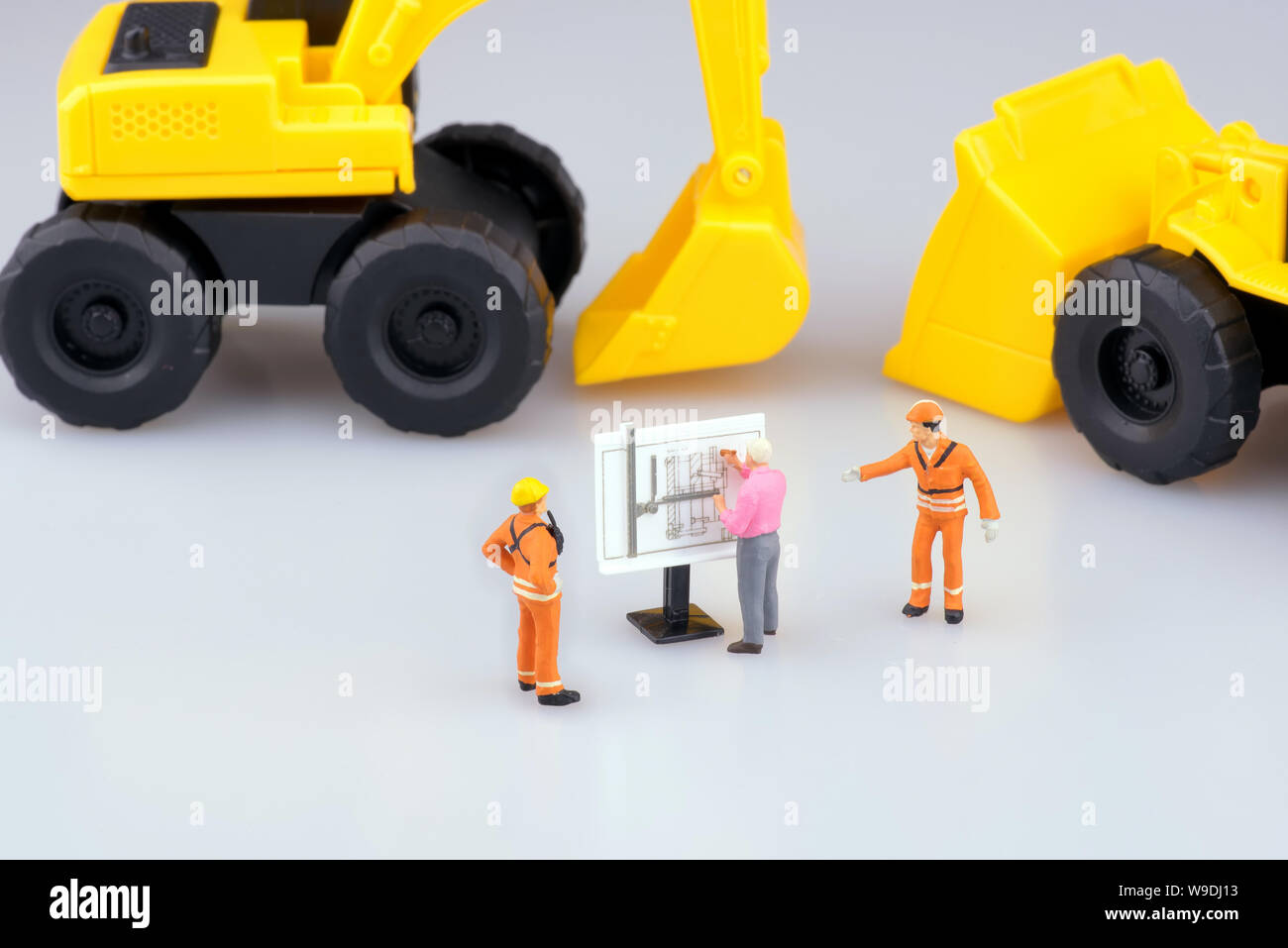 Miniature engineering people and architecture working on construction ...