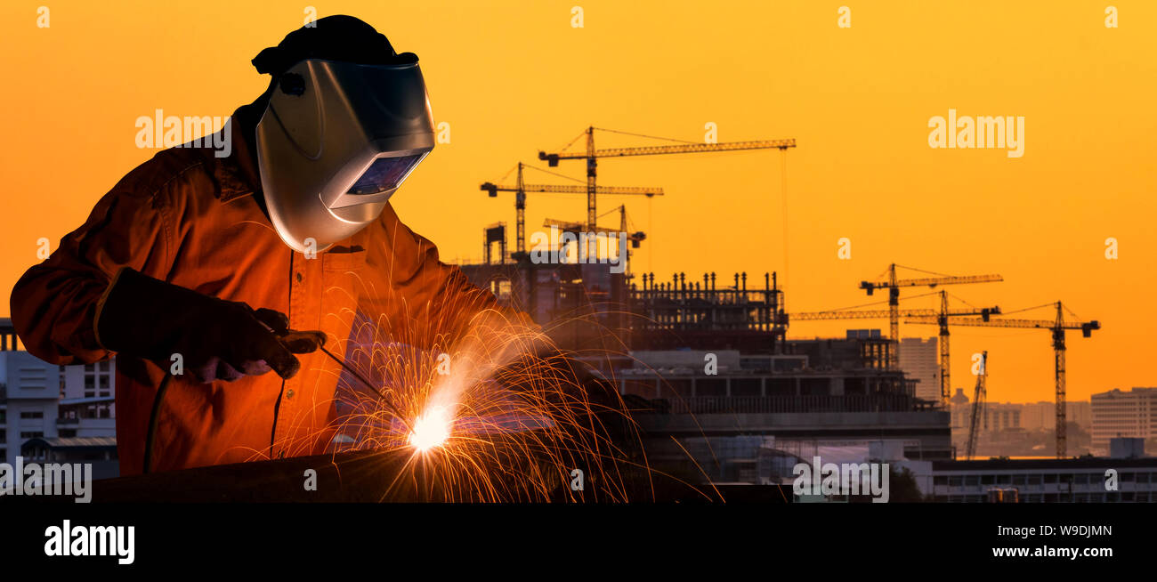 Industrial worker welding steel structure for infrastructure building ...