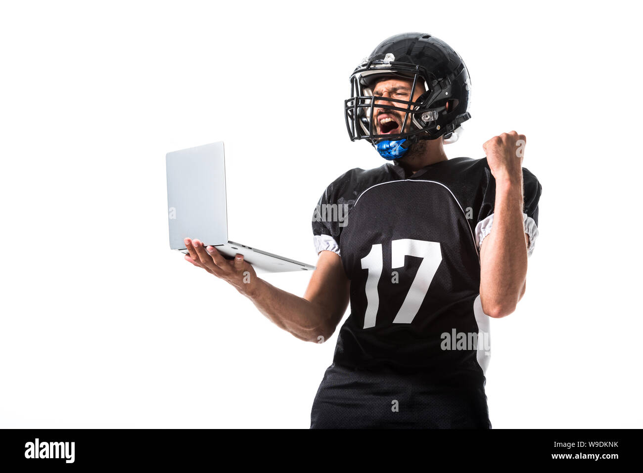 American Football player with laptop cheering with clenched hand ...