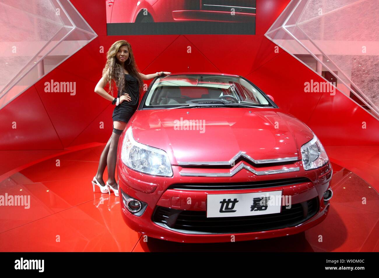 --FILE--A Chinese model poses with a Citroen C-QUATRE, known as Chinese ...
