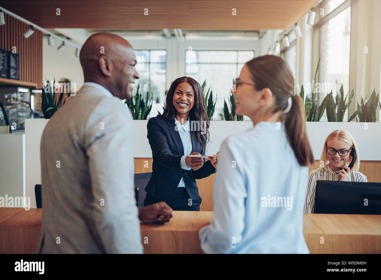 Friendly young African American concierge working at a reception ...