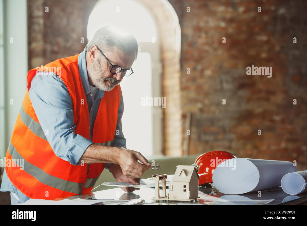 Close up photoshot of male architect-engineer making a model of future ...