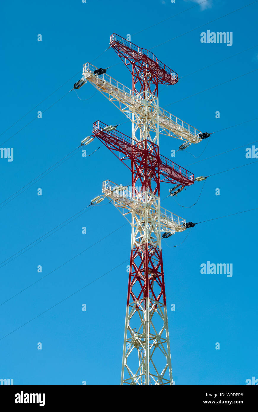 high-voltage power line support painted in red and white colors ...