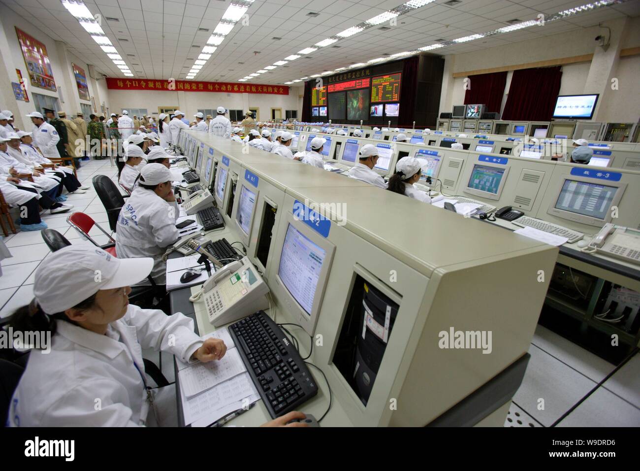 Chinese aeronautical scientists and workers monitor the blast-off of ...