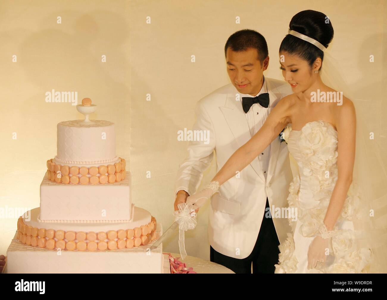 Hong Kong singer and actress Kelly Chen (R) cuts cake with her husband ...