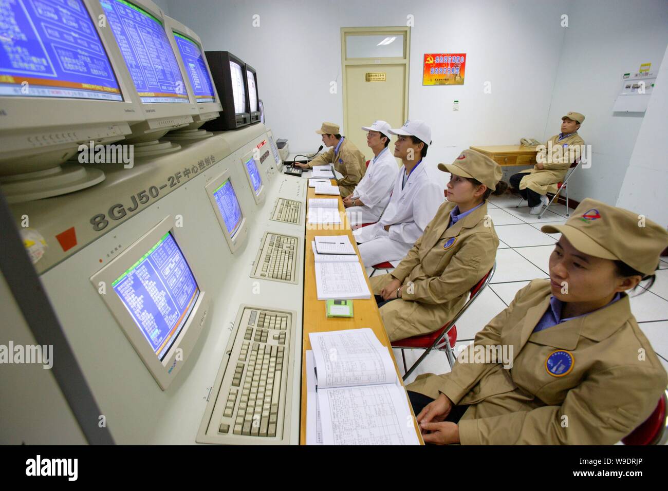 Chinese aeronautical scientists and workers monitor screens in a ...