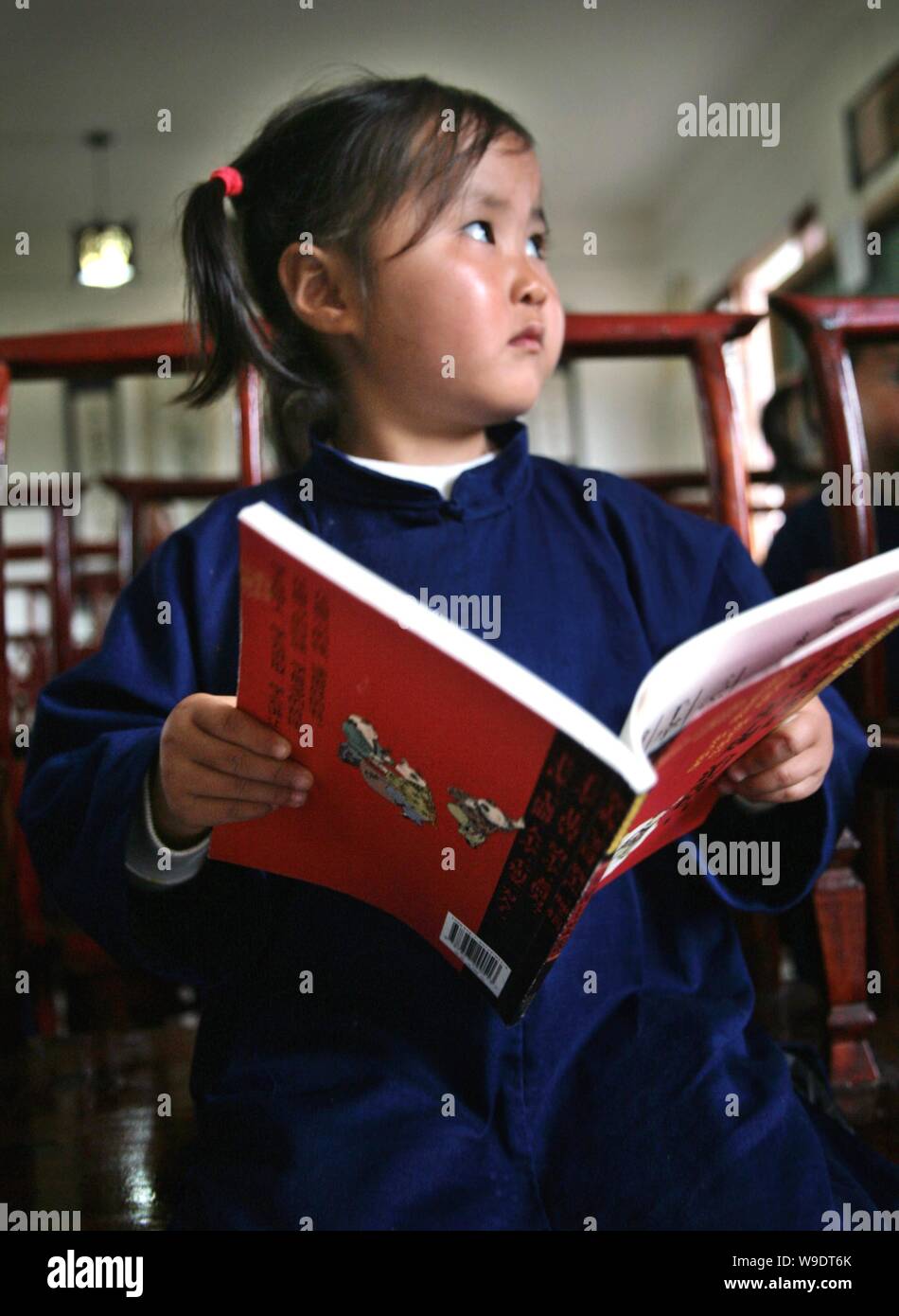 A Chinese young student wearing traditional Chinese costume learns ...