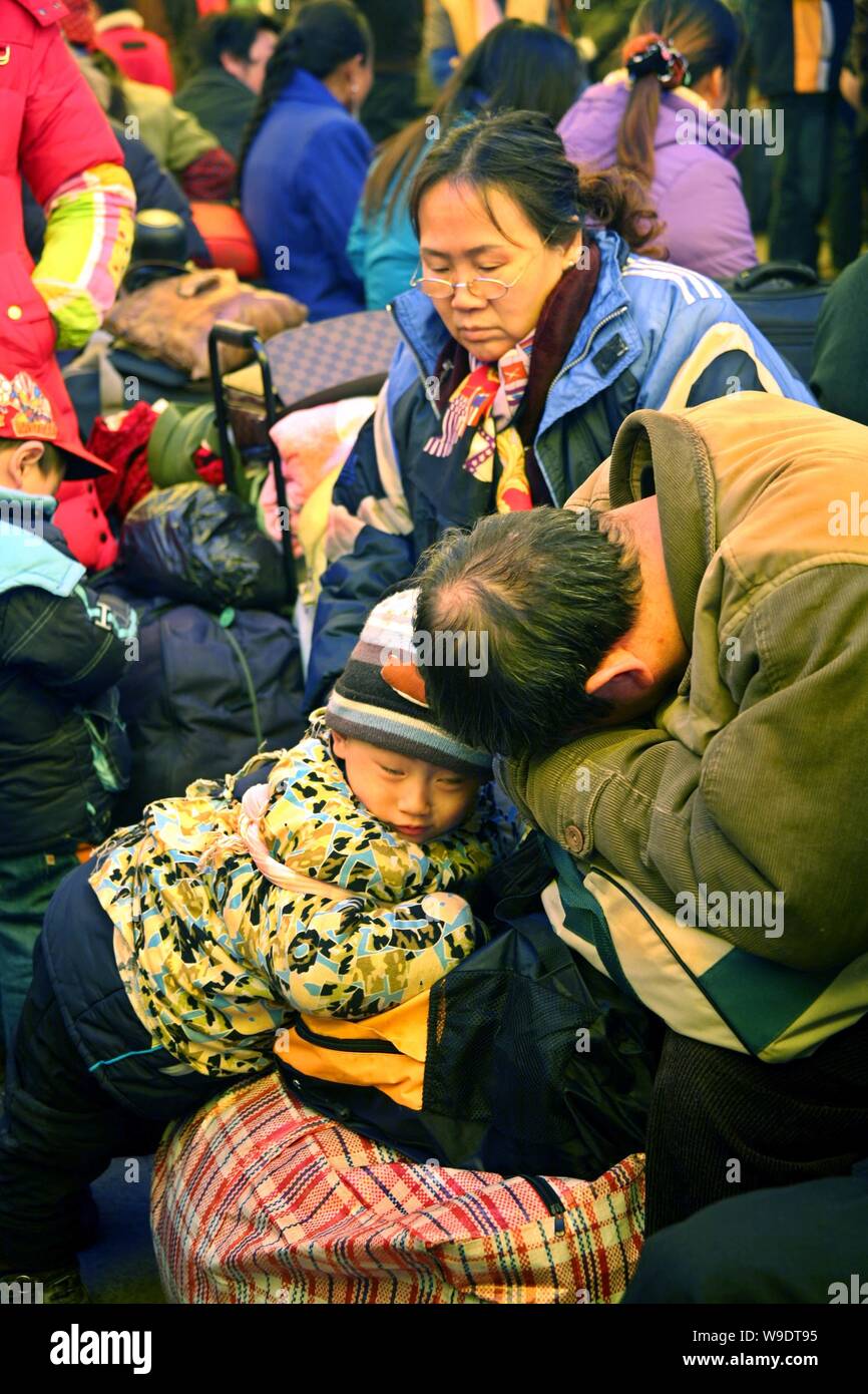 Chinese travelers rest in a temporary shelter at the railway station in ...