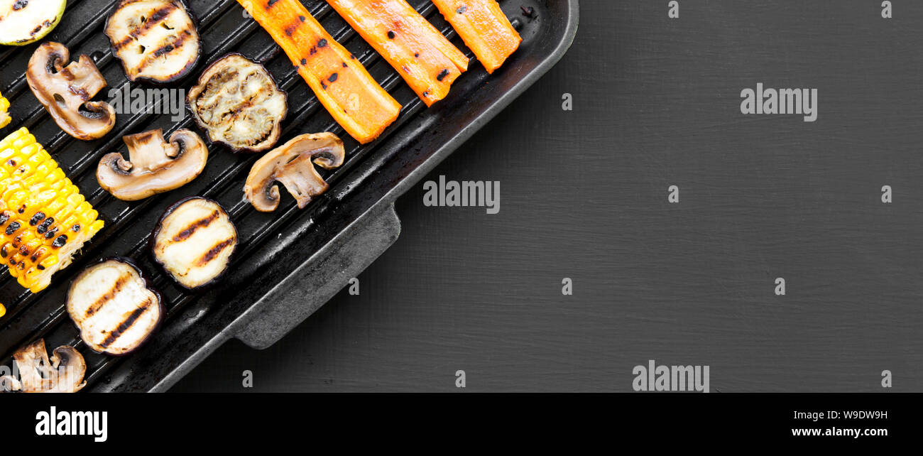 Grilled vegetables in a grilling pan on a black background, top view ...