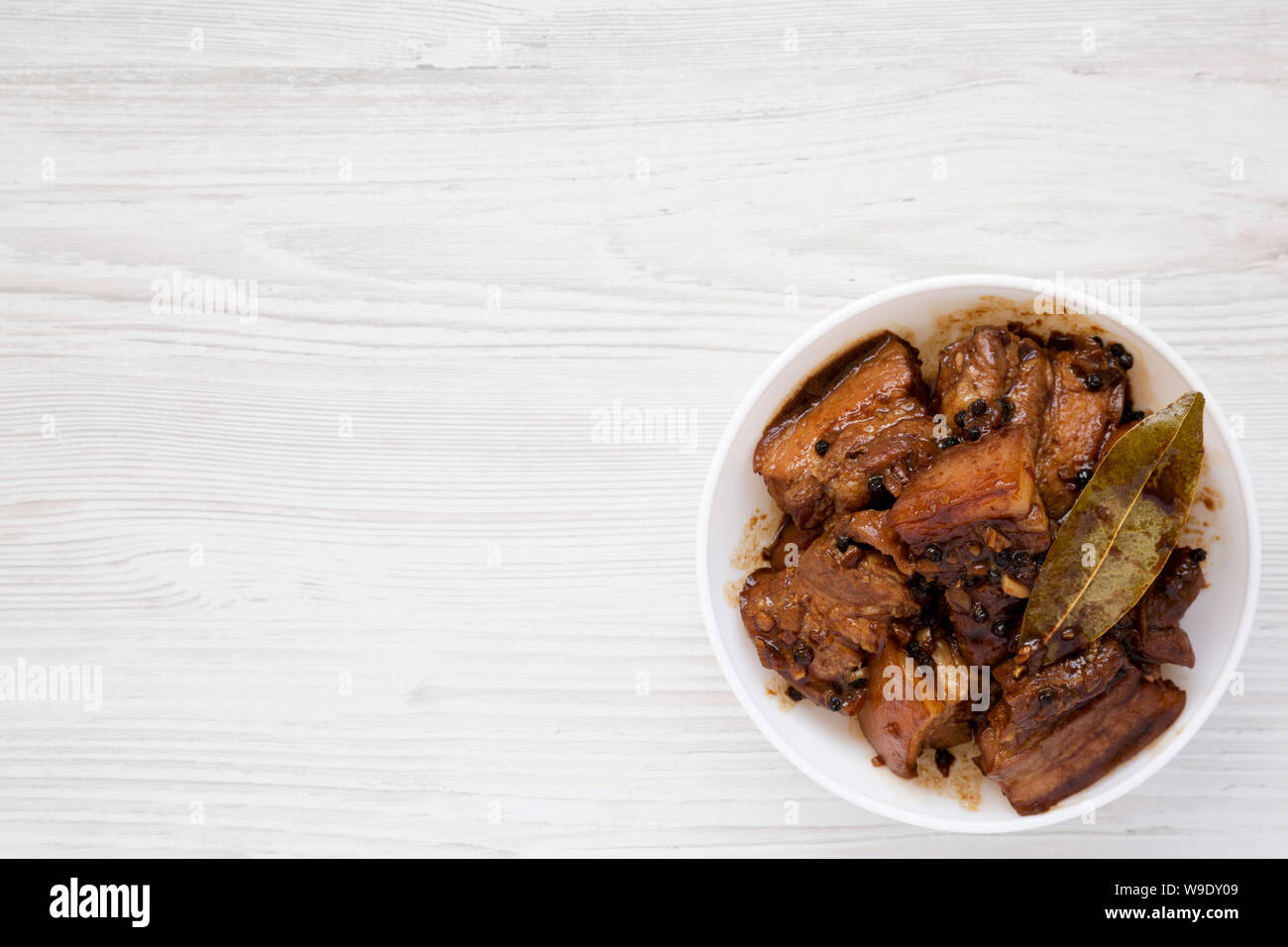 Homemade Filipino Adobo Pork in a white bowl, overhead view. Flat lay ...