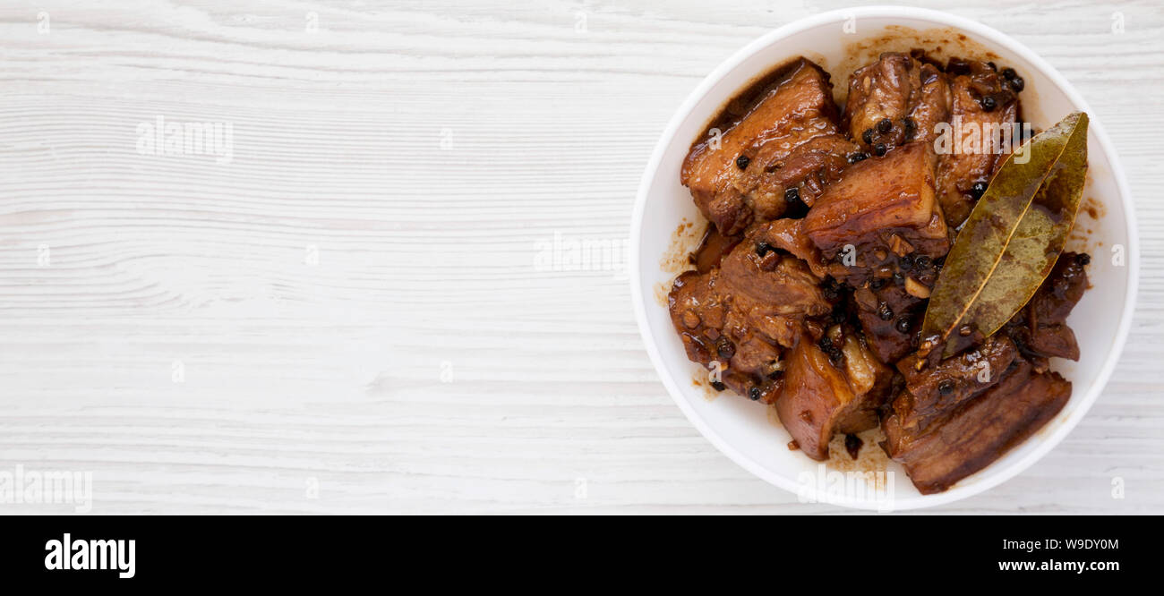 Homemade Filipino Adobo Pork in a white bowl over white wooden ...