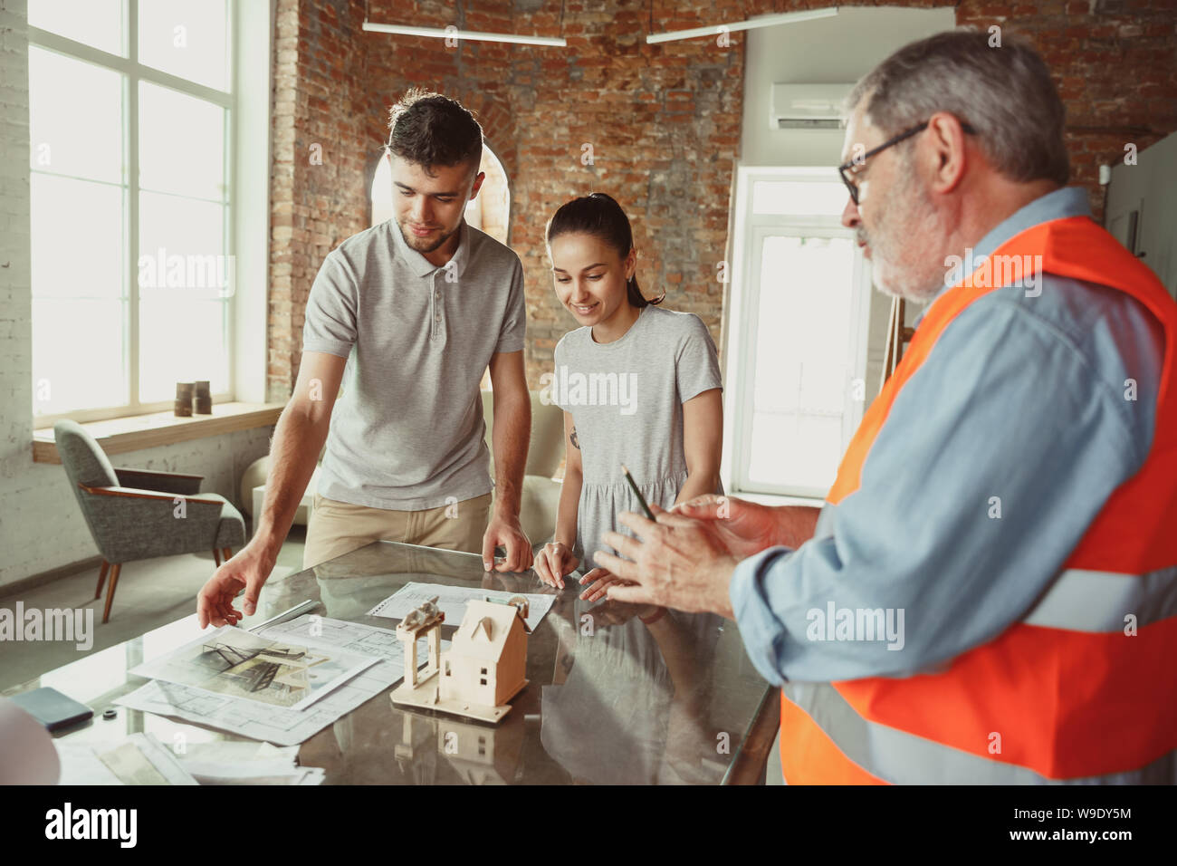 Foreman or achitect engineer shows future house, office or store design ...