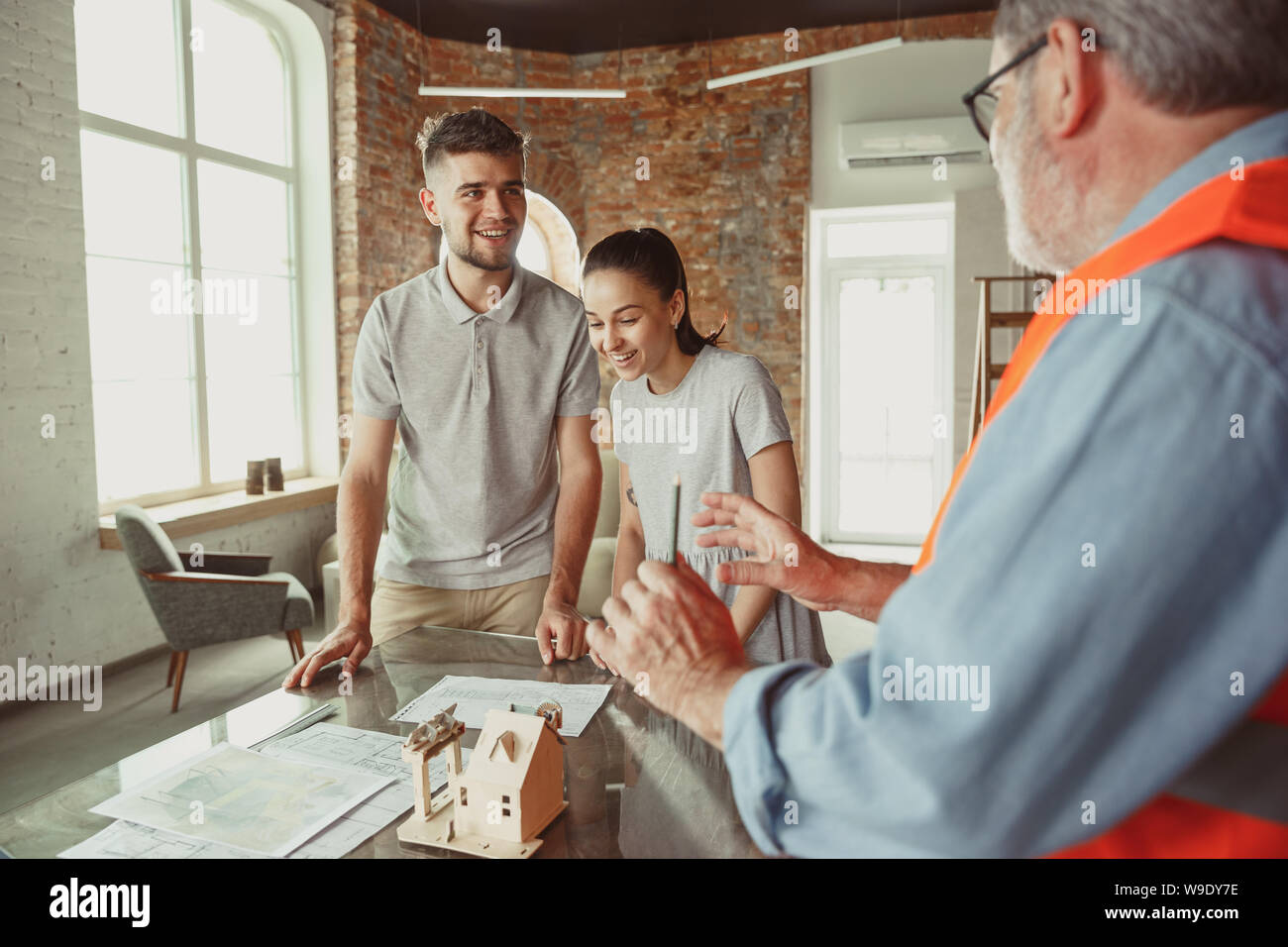 Foreman or achitect engineer shows future house, office or store design ...