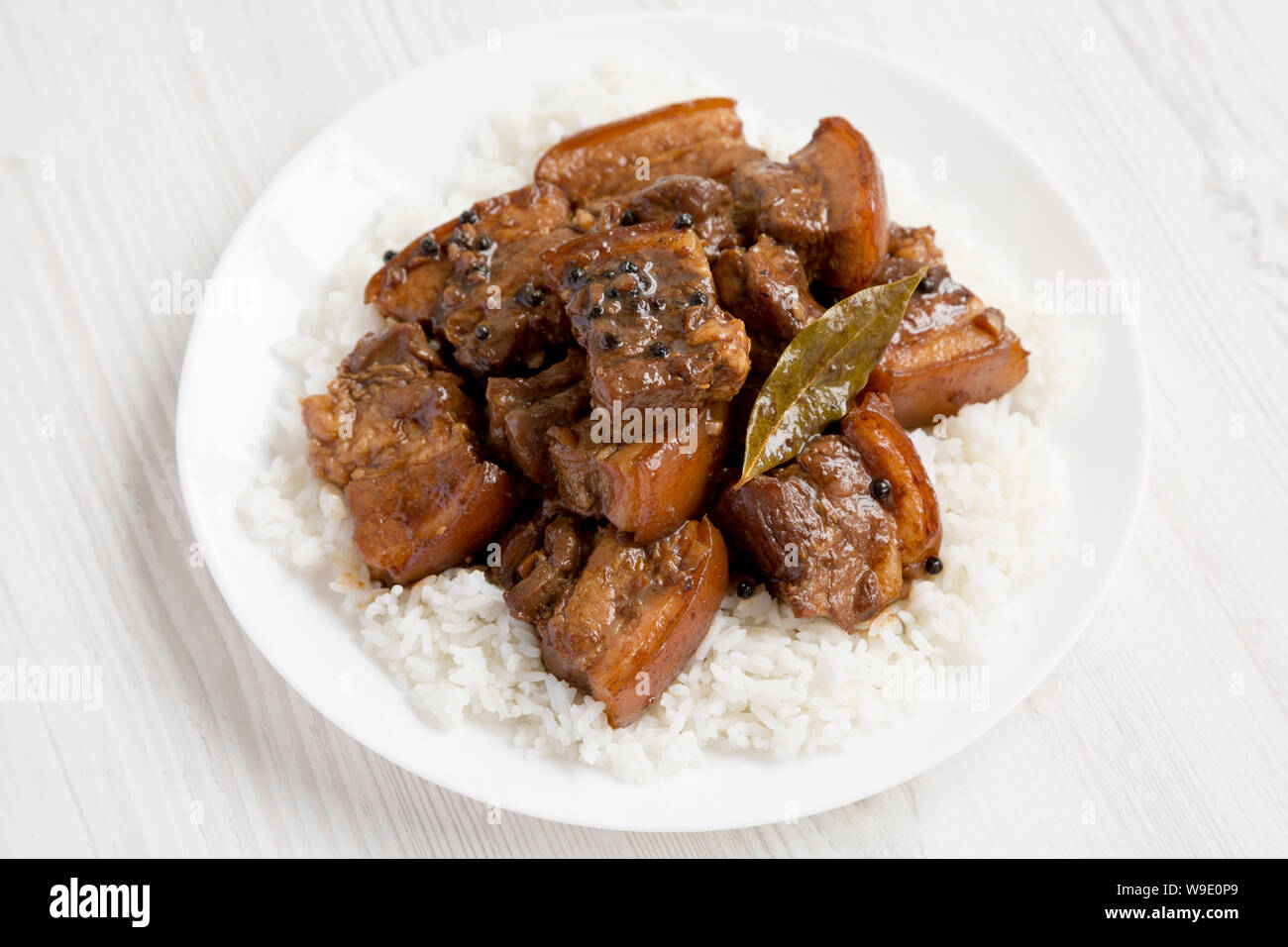 Homemade Filipino Adobo Pork with rice on a white plate over white ...