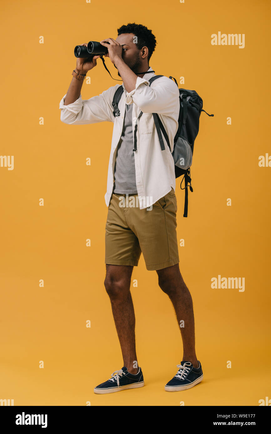 african american man looking through binoculars on orange Stock Photo ...