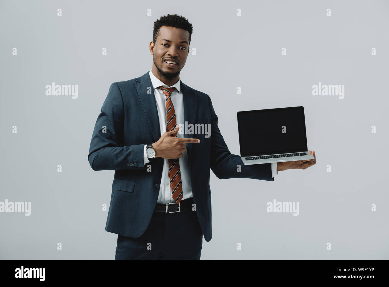 happy african american man pointing with finger at laptop with blank ...