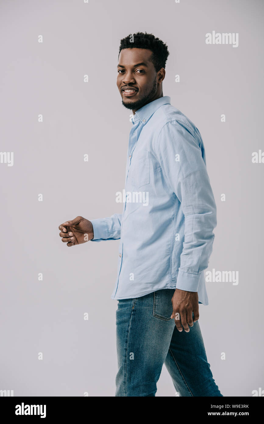 happy african american man walking and gesturing isolated on grey Stock ...