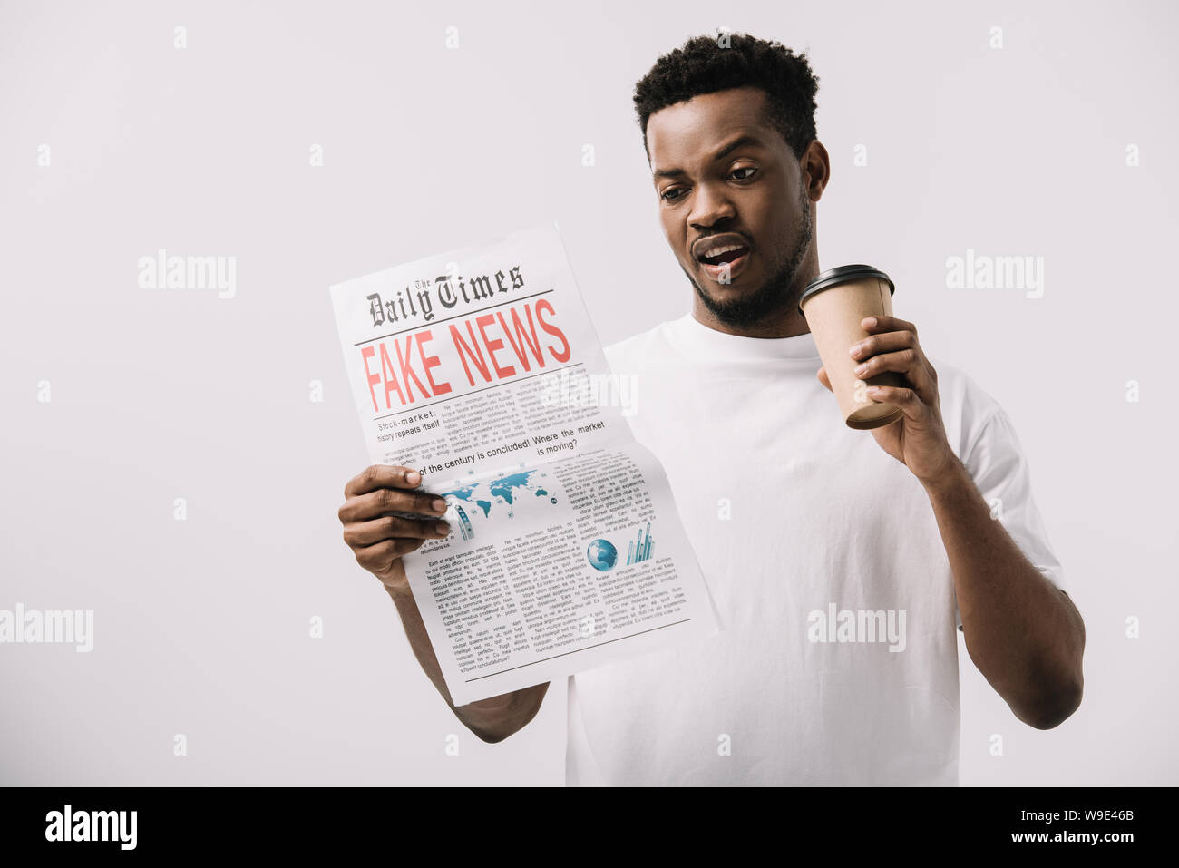 surprised african american man holding paper cup and reading newspaper ...
