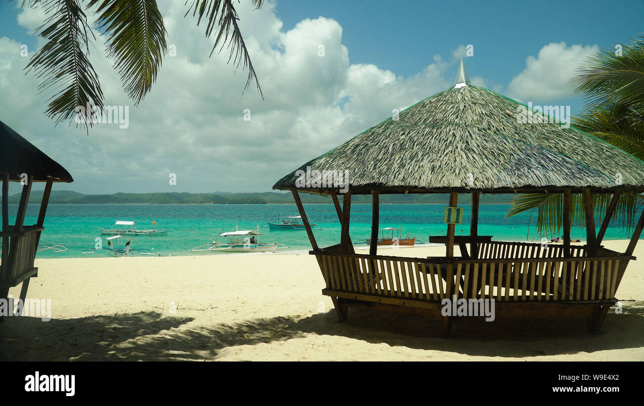 Bungalow on a tropical beach with palm trees and blue sea of Daco ...