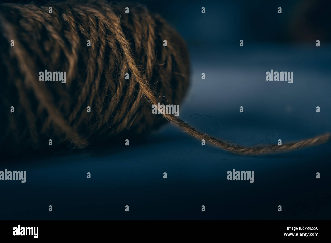 Jute string roll close up on blue background Stock Photo - Alamy