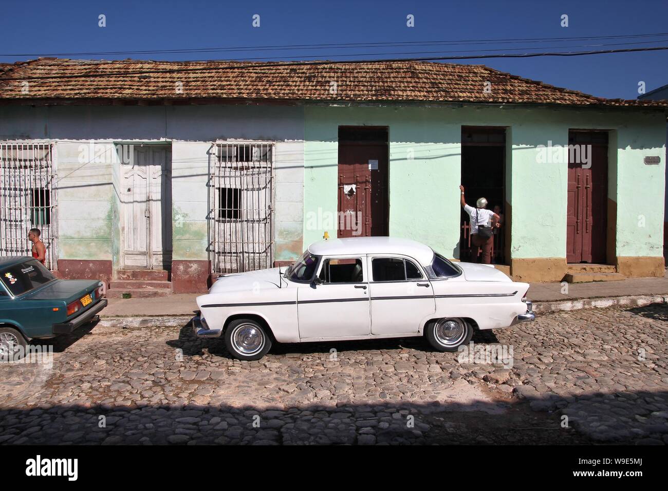 TRINIDAD, CUBA - FEBRUARY 5, 2011: People walk by oldtimer American ...
