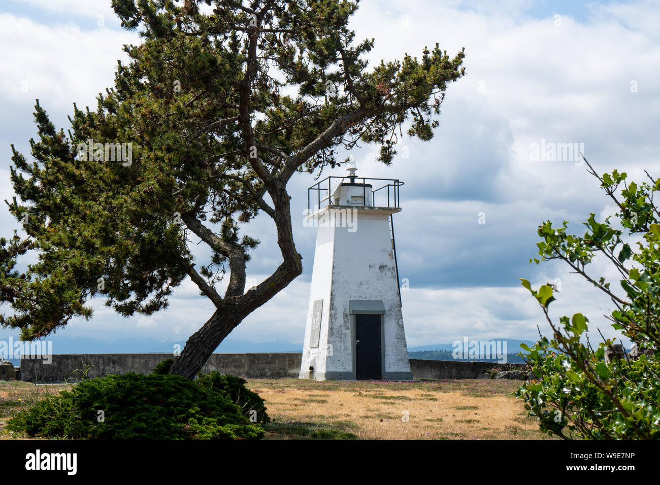Bush Point Lighthouse, with trees framing the nautical structure on a ...
