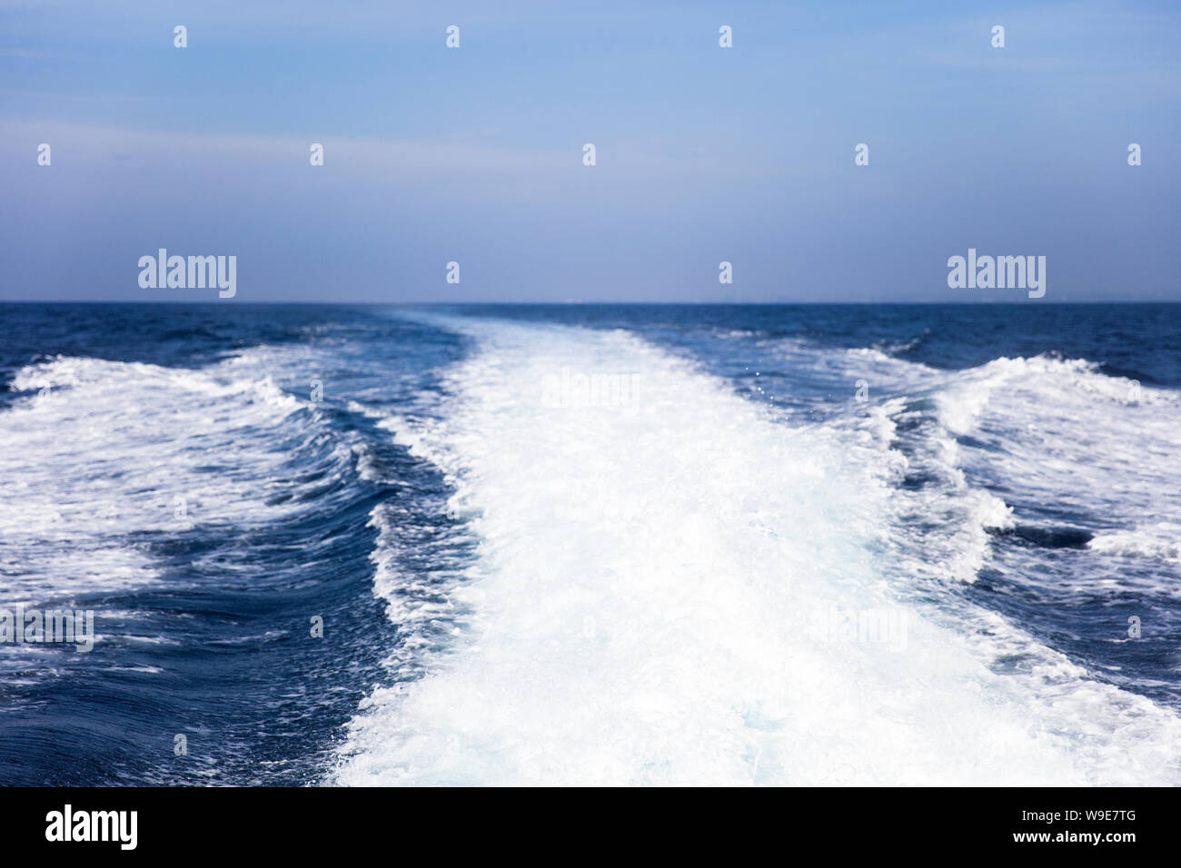 Water splash behind the speed boat in the ocean with beautiful blue sky ...