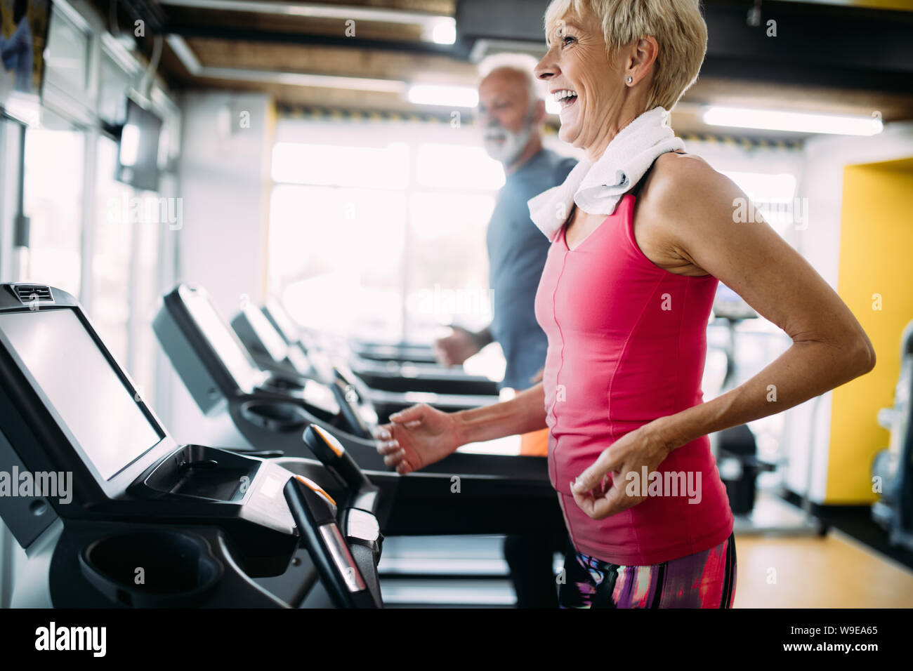 Happy senior people running together on treadmills in gym Stock Photo ...